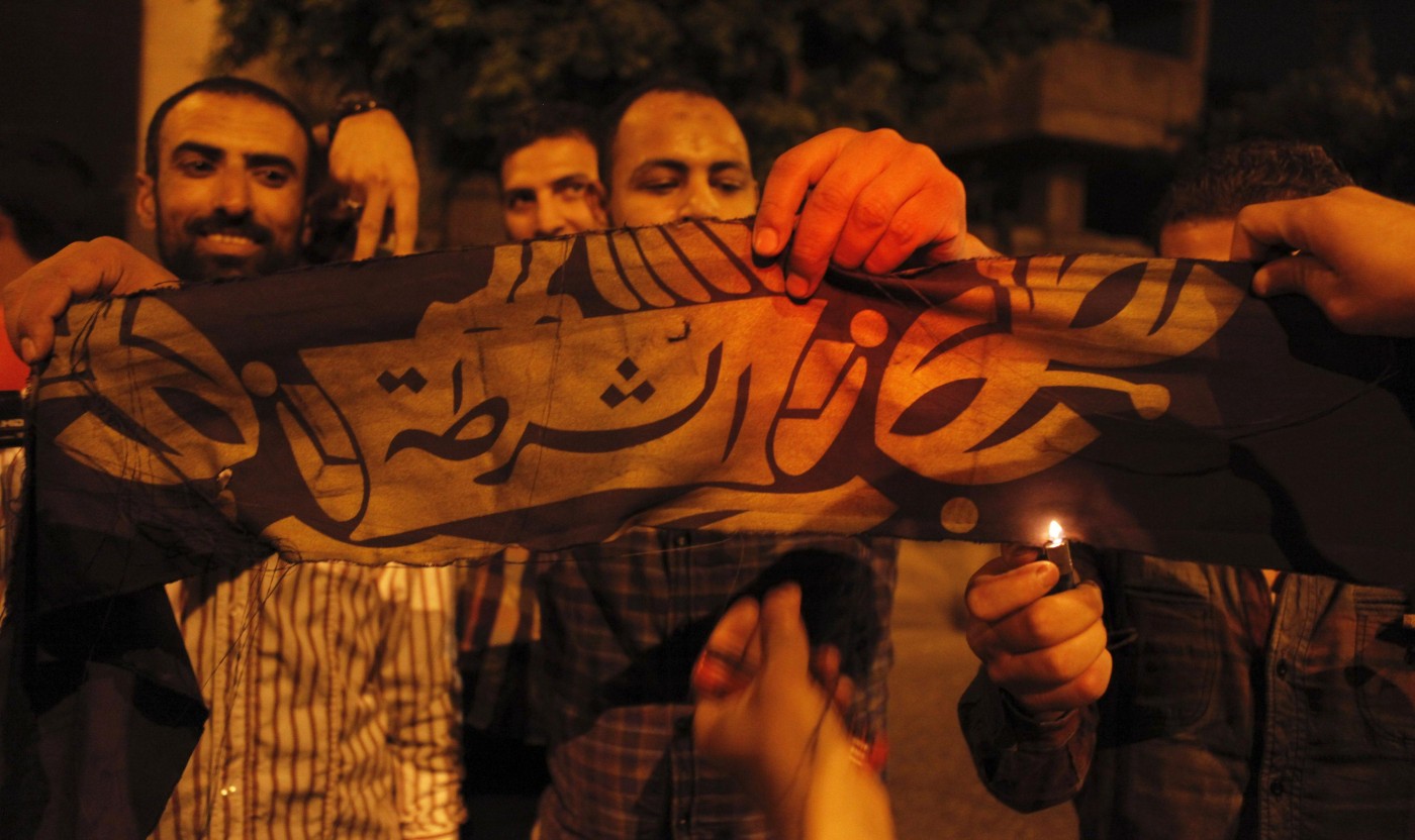 Islamist protesters shout slogans and burn a flag, after they took it ...