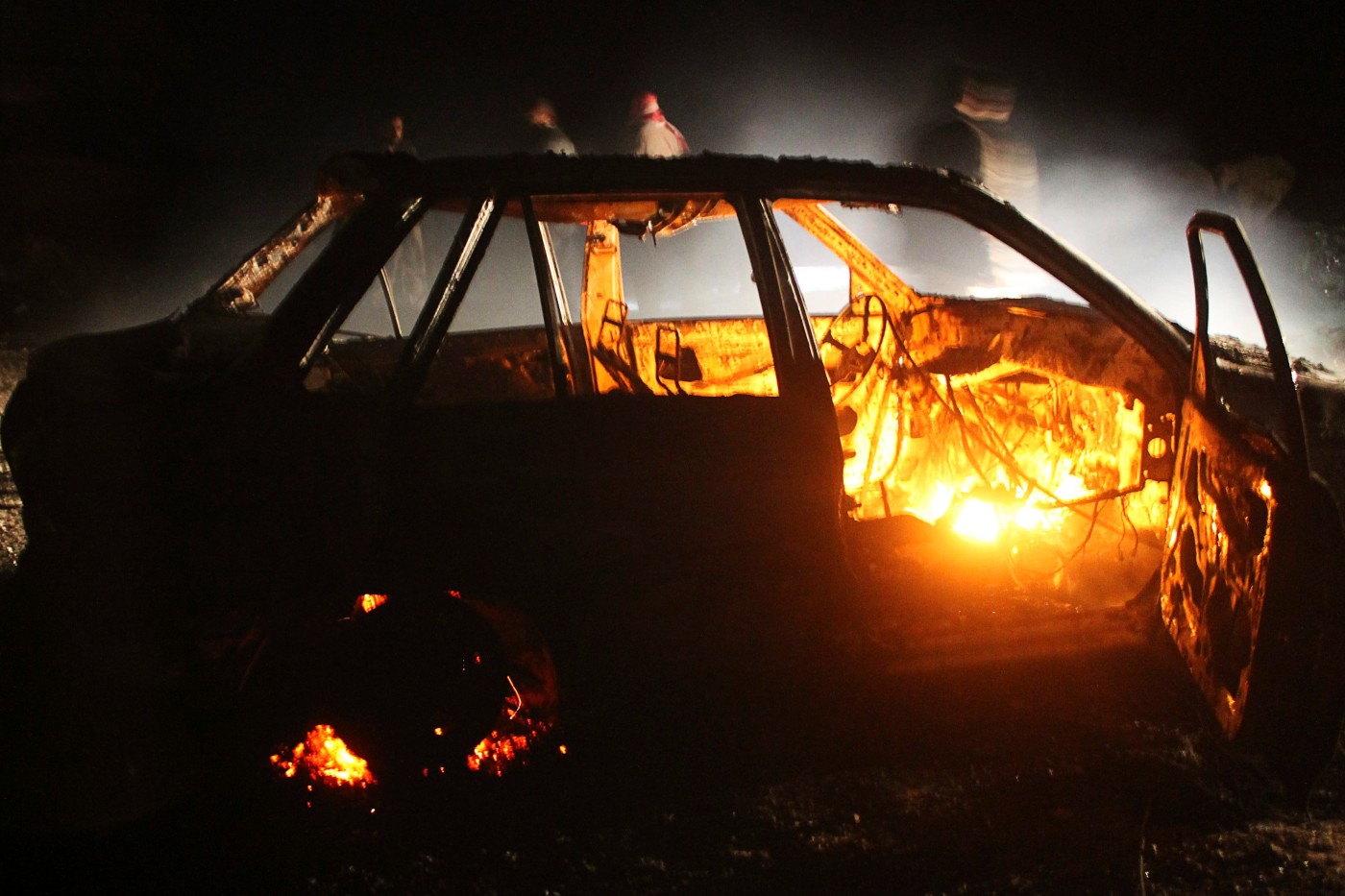 Smoke rises from a burnt car after what activists said was a car bomb ...