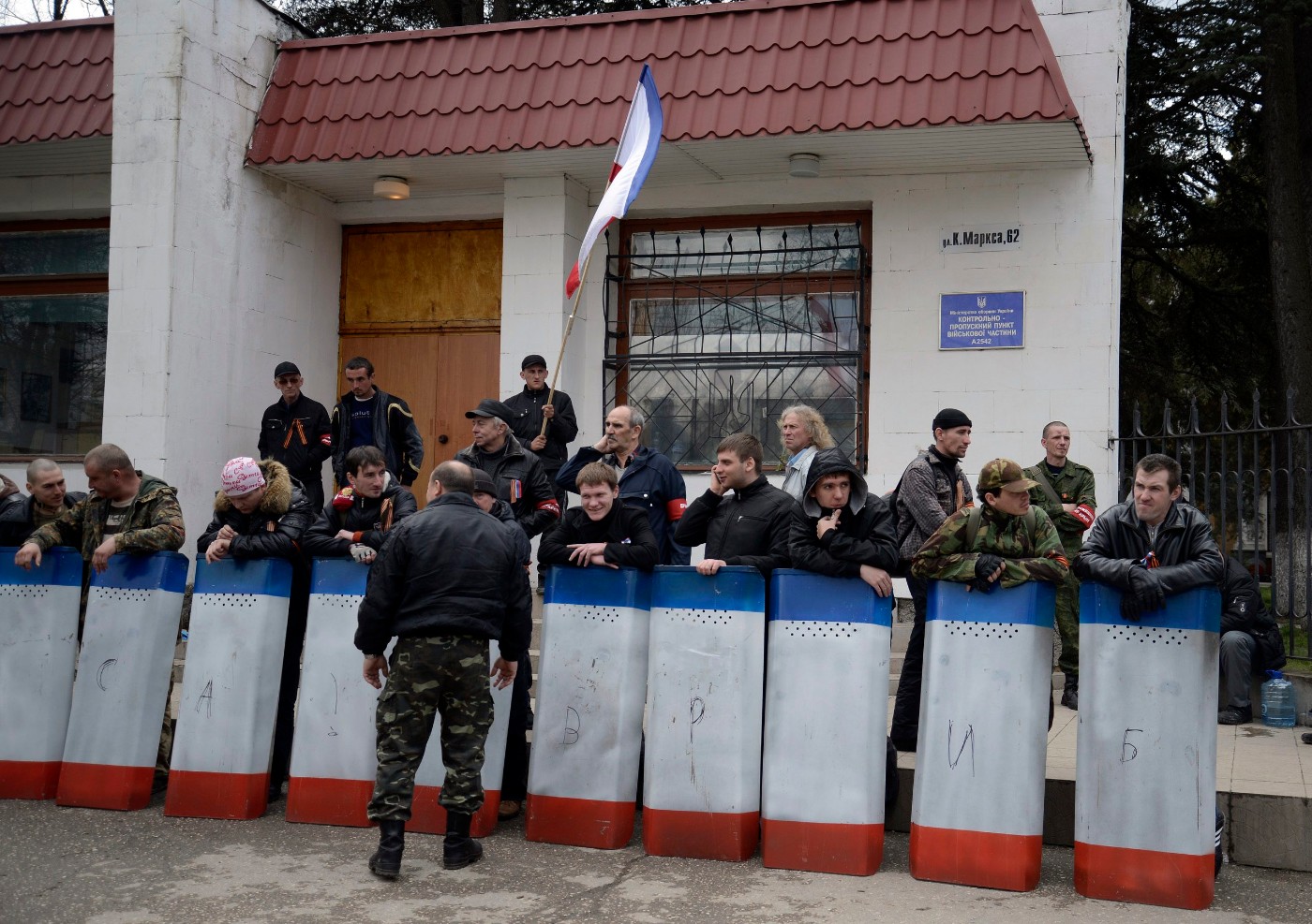 A group of pro-Russia activists with riot shields look on during an ...