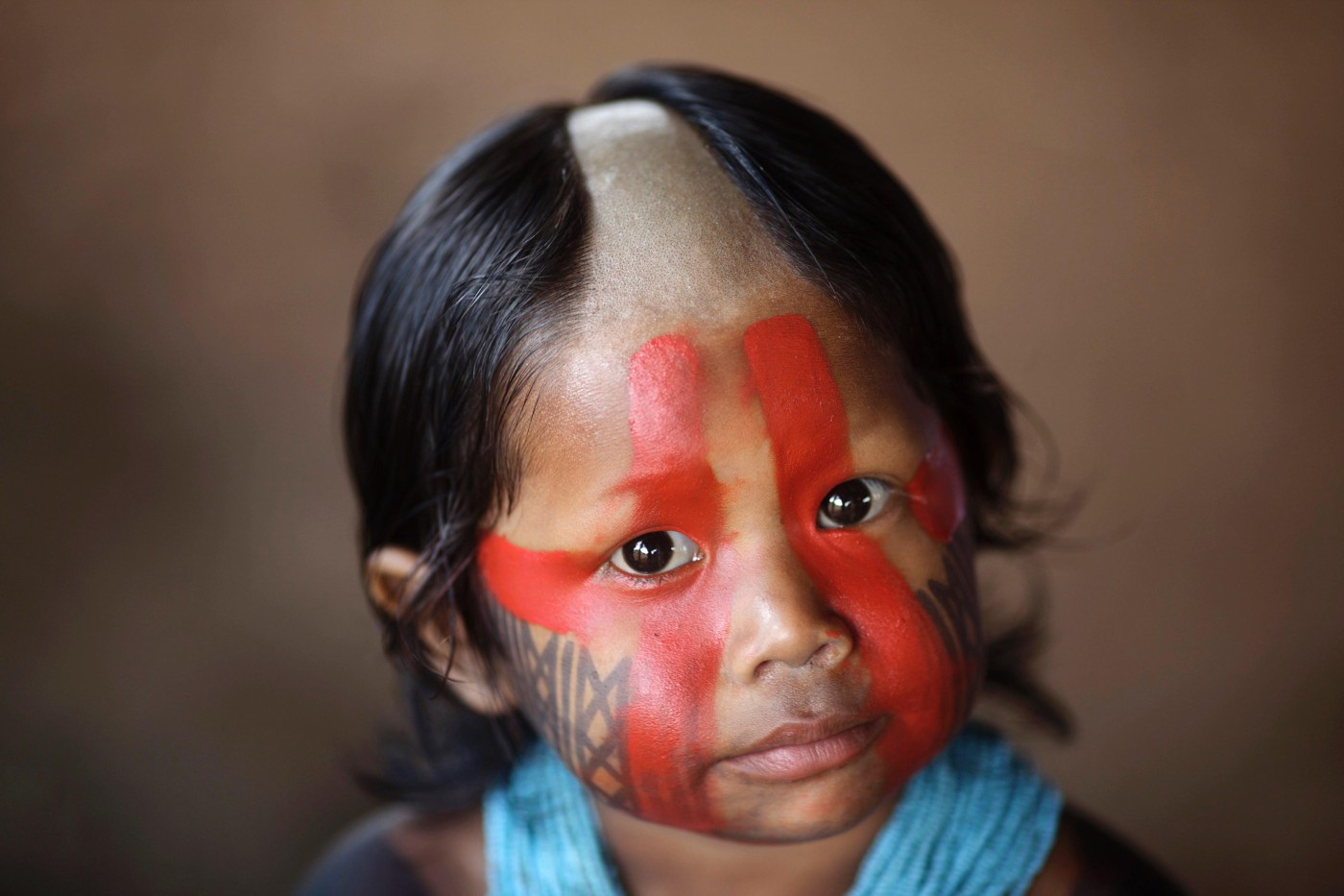 A child from Kayapo tribe with traditional face paint and hair cut ...