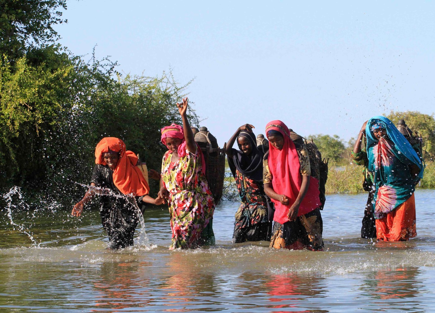 Women wades cross the flooded Shebelle River in Jowhar for higher ...