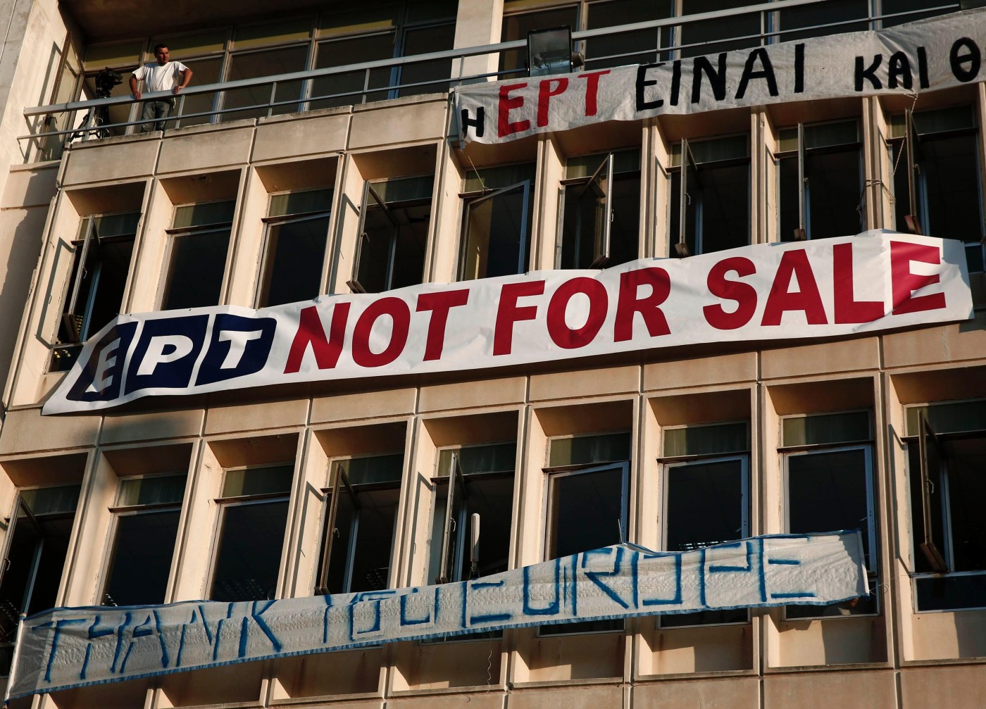 A cameraman stands at a balcony of Greek state broadcaster ERT ...