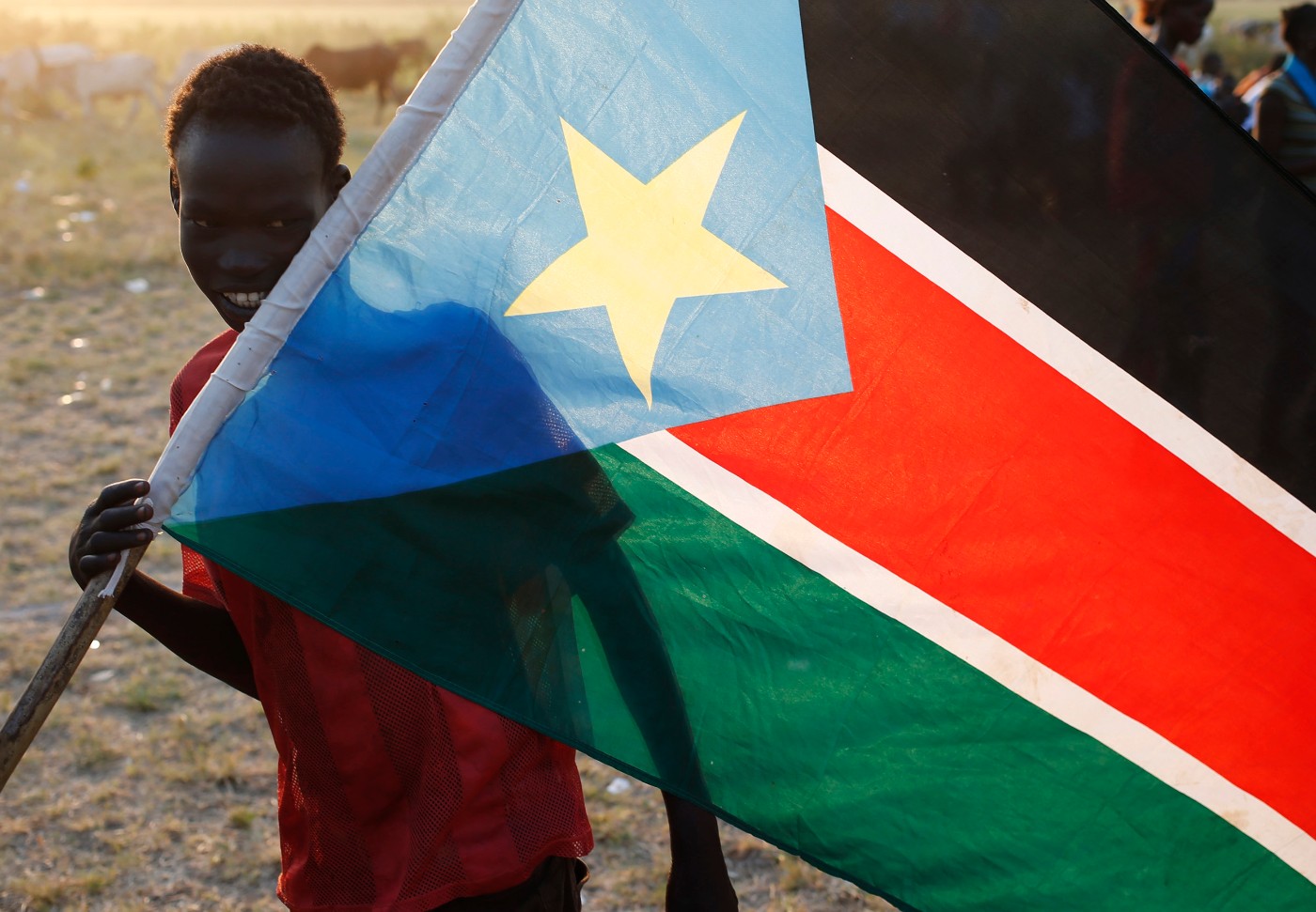 A man holds South Sudan's national flag as he celebrates referendum ...
