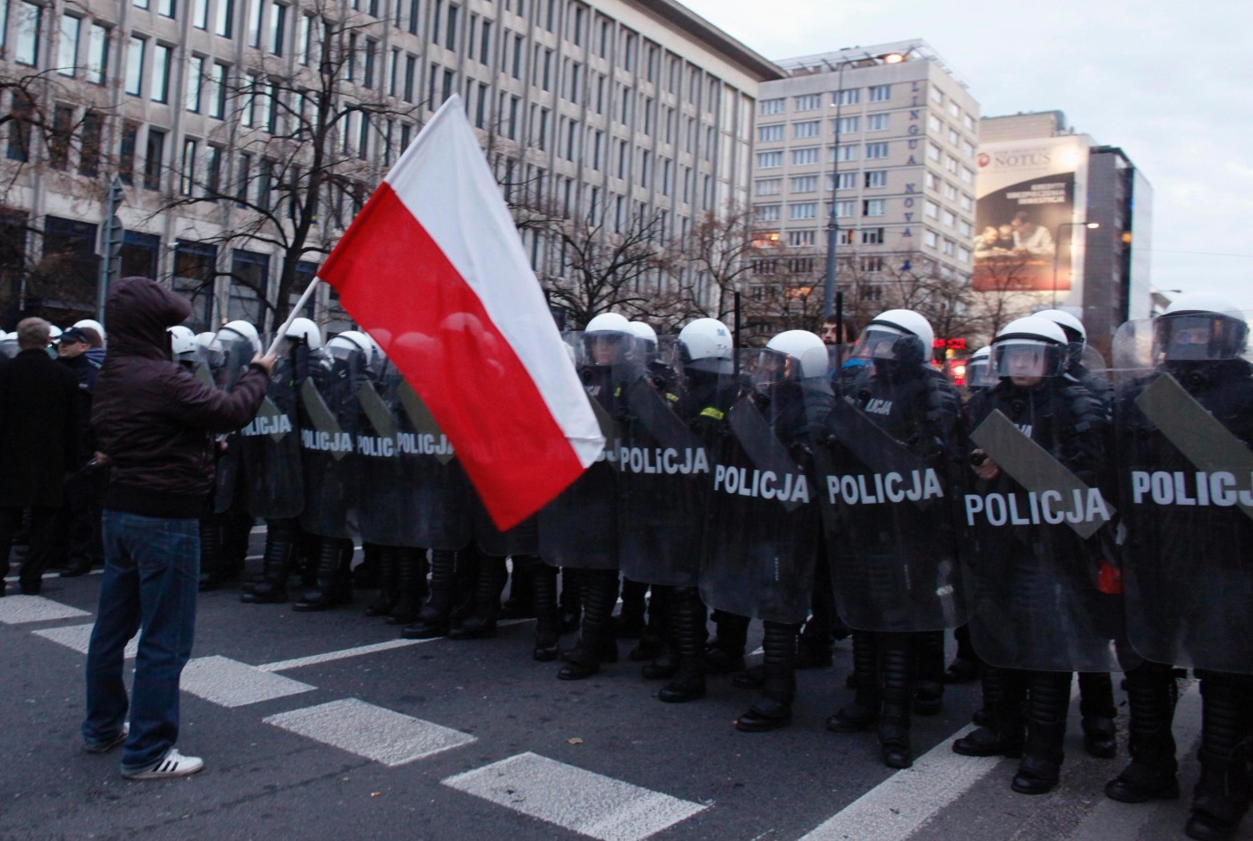 A demonstrator stands in front of riot police as violence breaks out at ...