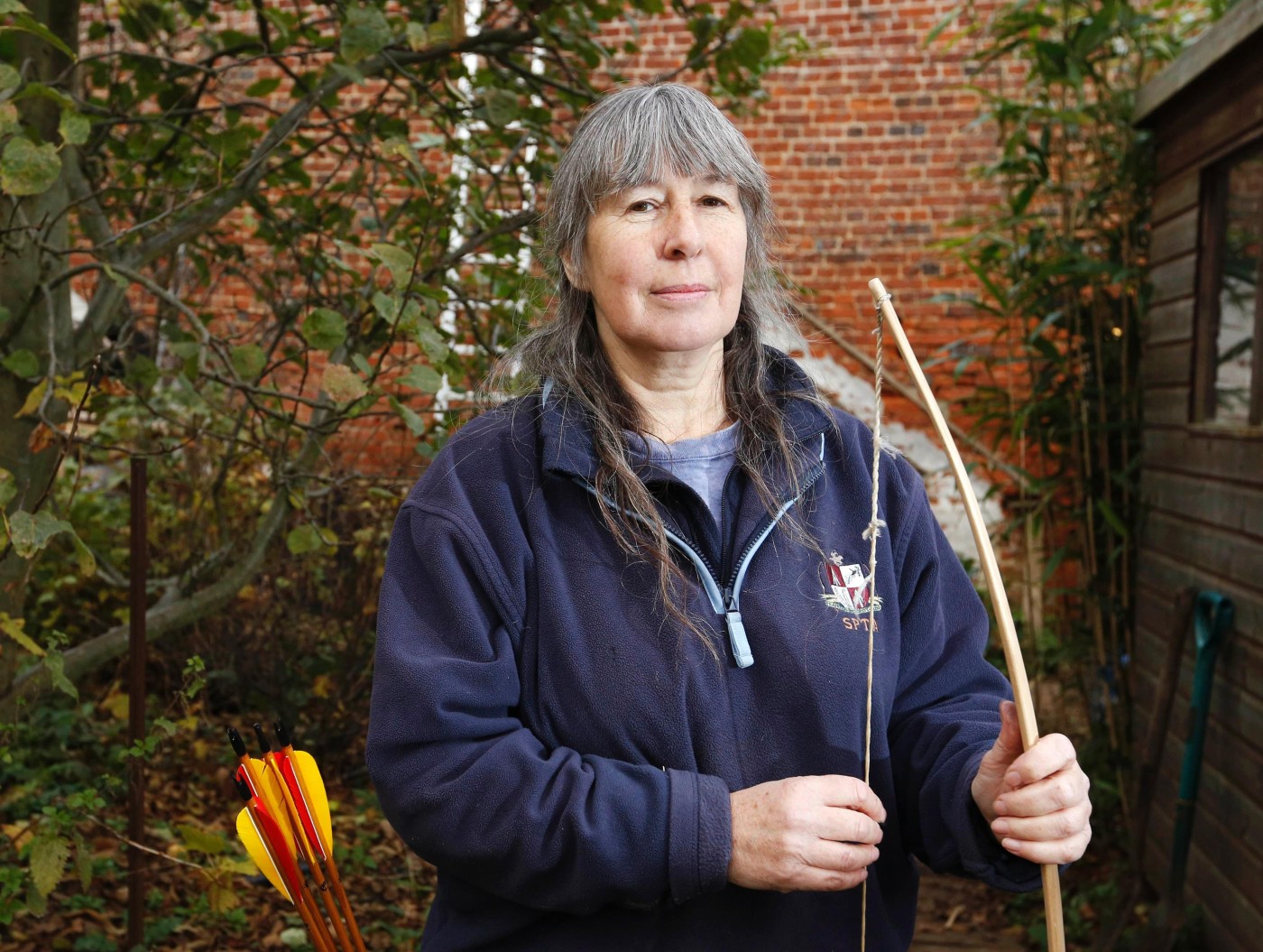 Archer Carol Pearce poses with a bow and arrows made from ash, at her ...