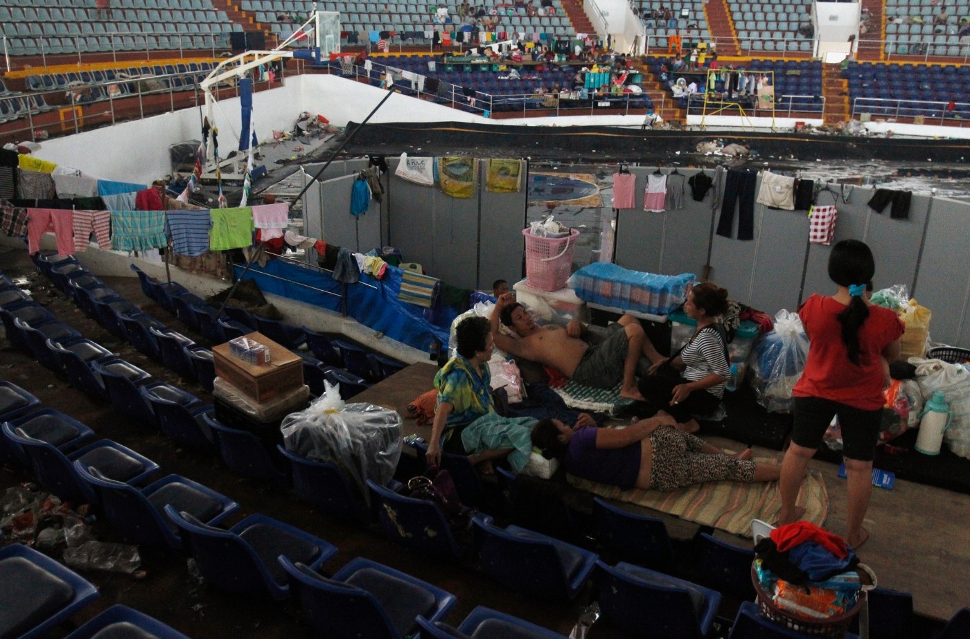 Families take refuge in indoor basketball stadium at Tacloban City ...