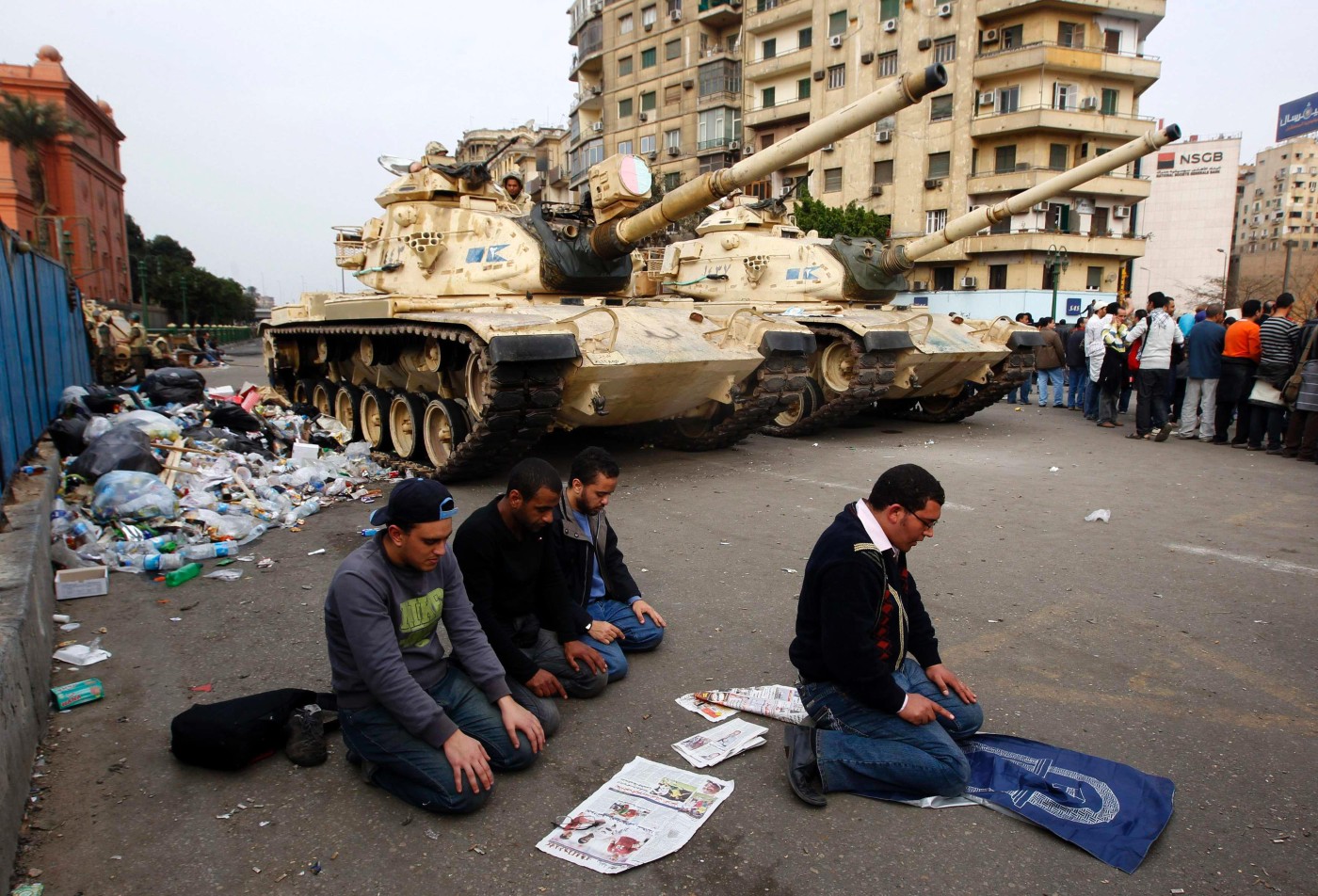 Protesters pray in front of Army tanks during a mass demonstration ...