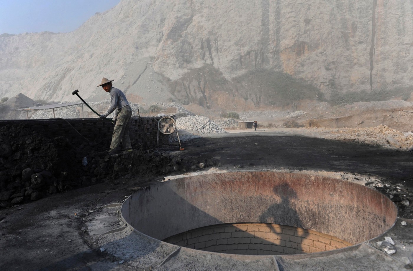 File photo of a worker smashing coal as he preparing to burn limestone ...