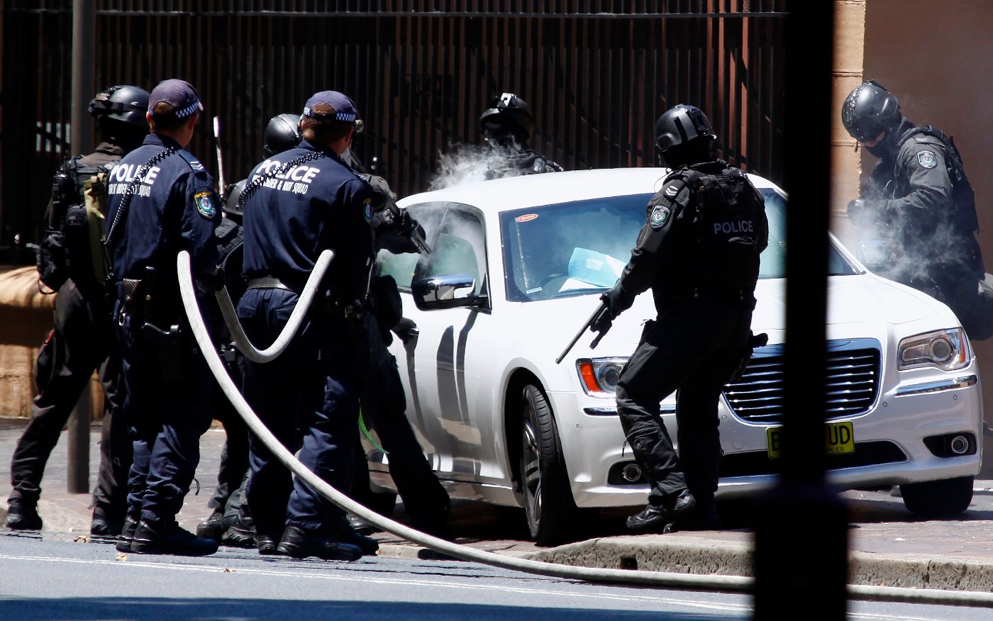 Heavily armed police officers prepare to drag a man from his car ...