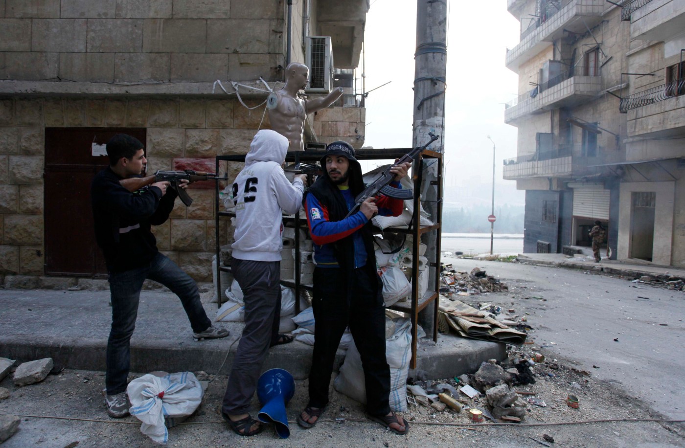 Free Syrian Army fighters hold their weapons as they stand near a ...