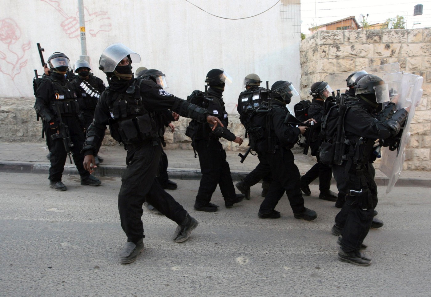 Israeli police officers stand behind riot shields during clashes with ...