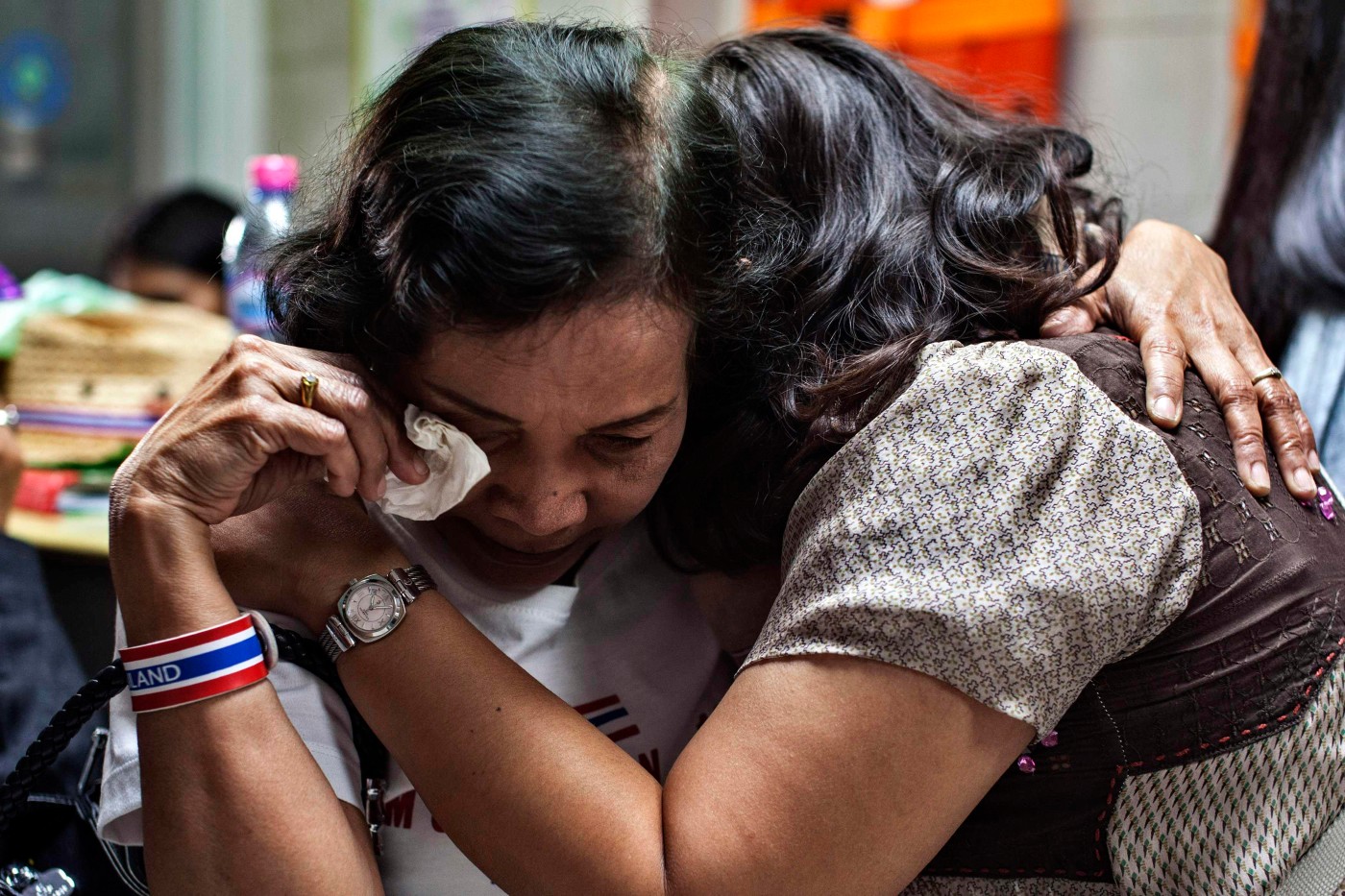 Relatives and friends of injured people embrace each other outside an ...