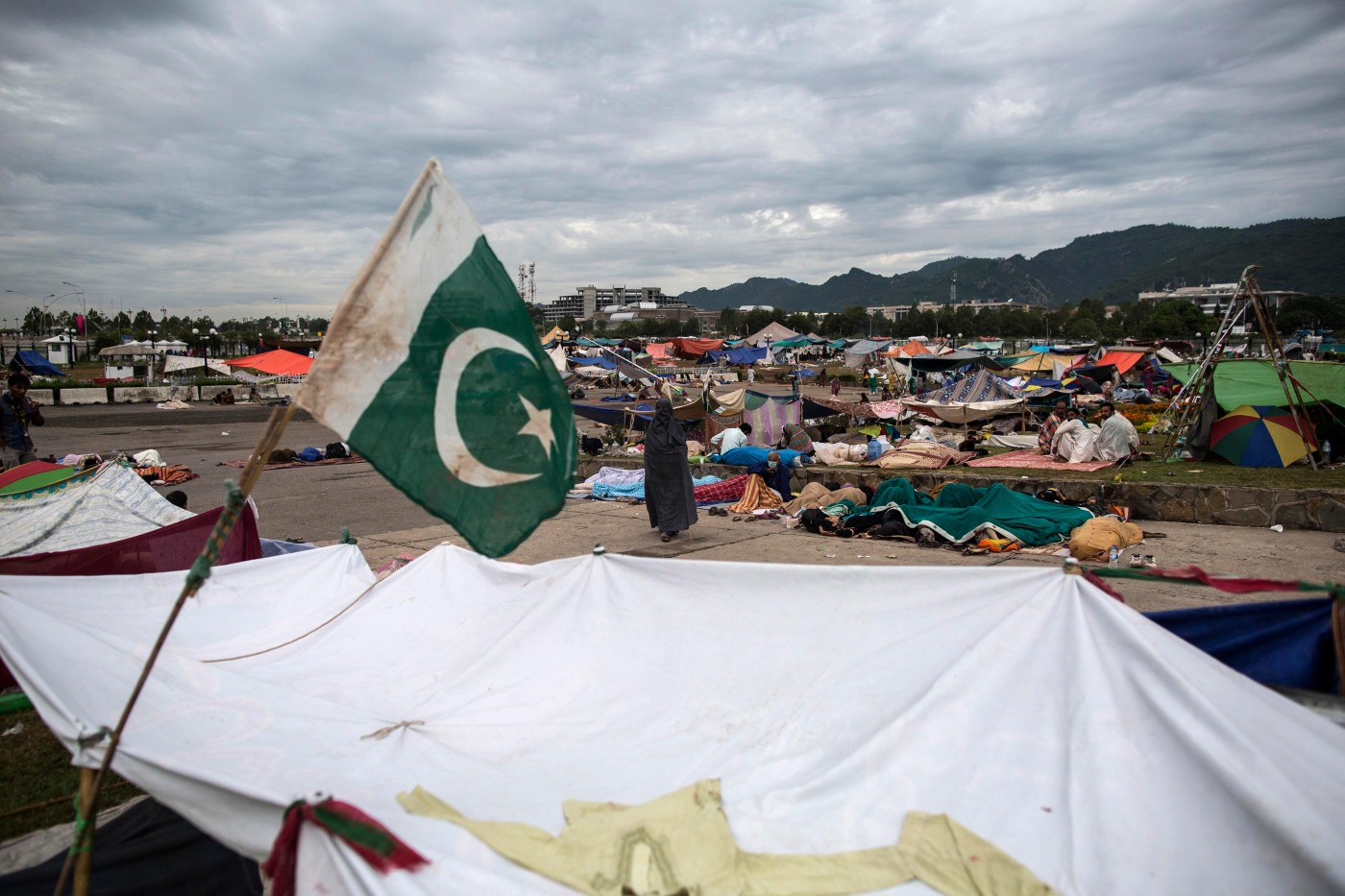 An anti-government protester walks past tents of her follow protesters ...