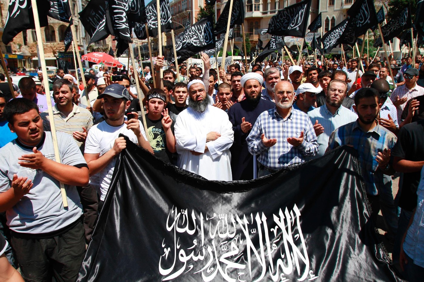 Lebanese Sunni Muslim Islamists hold a banner and flags after ...