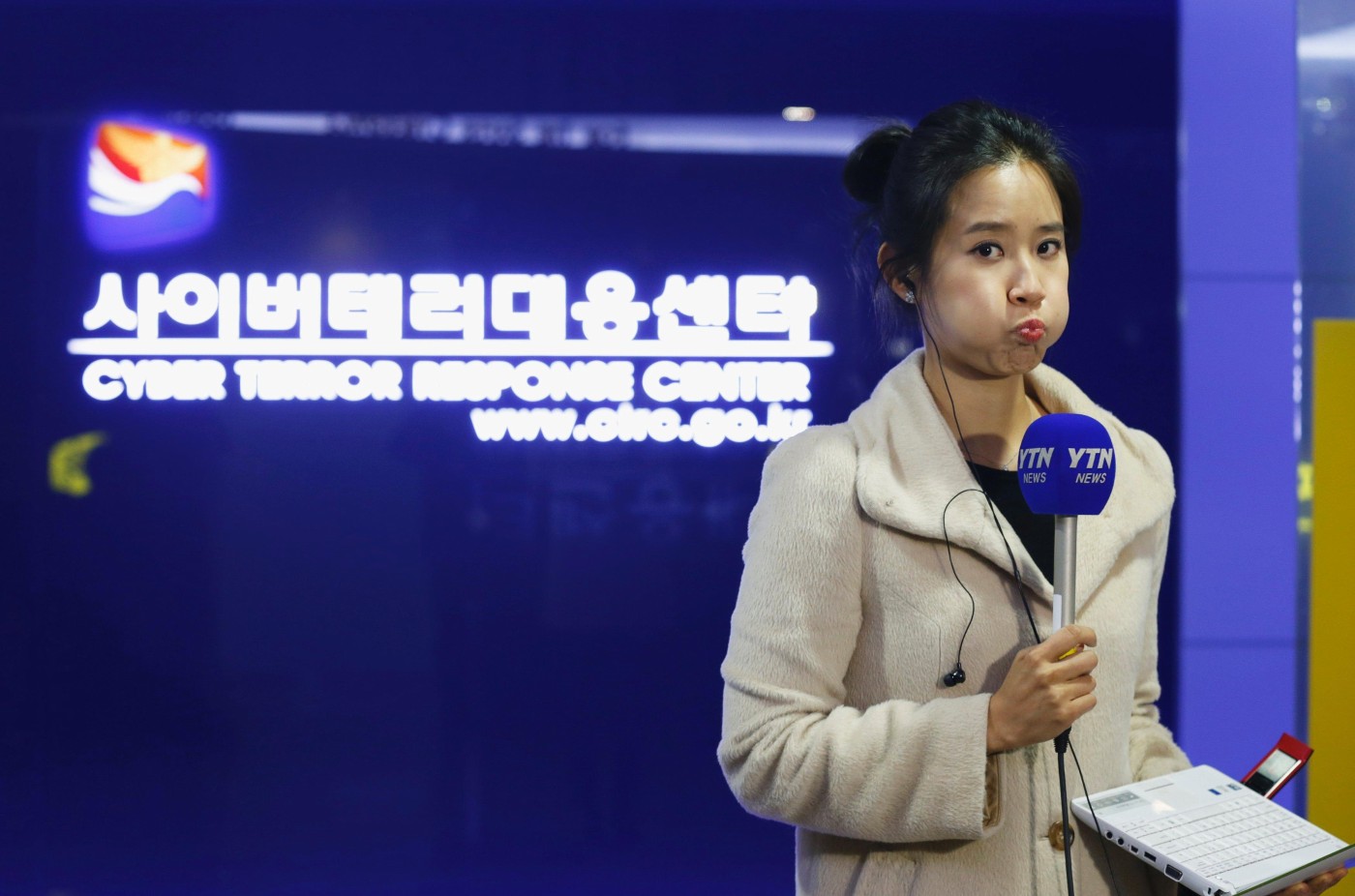 A reporter of YTN news channel prepares to report live in front of ...