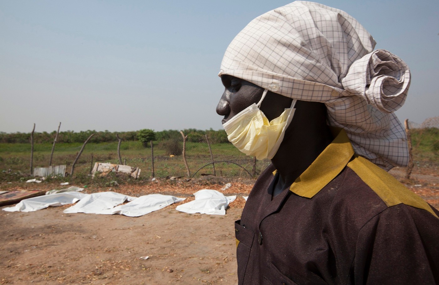 A man walks past decomposing bodies of fourteen women and two men ...