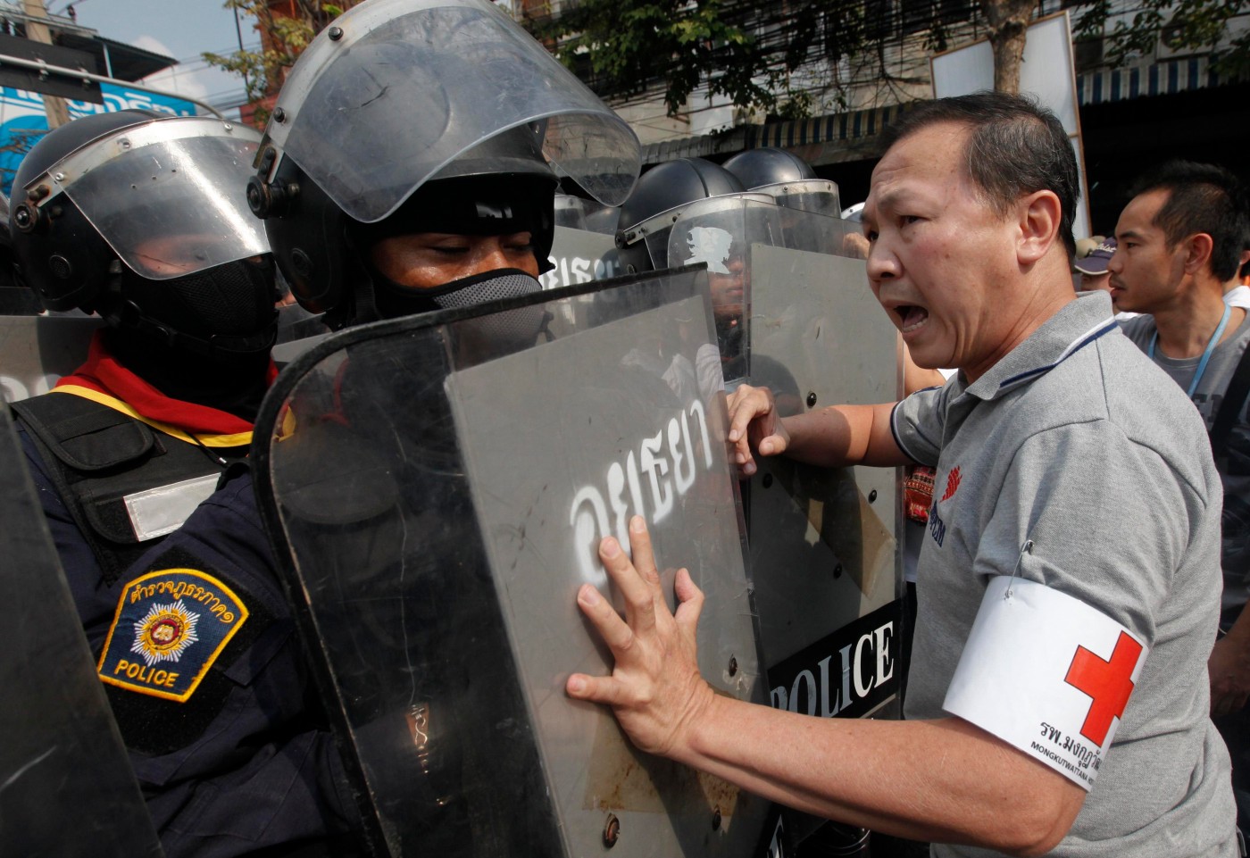 An anti-government protester pushes the shields held by riot police at ...