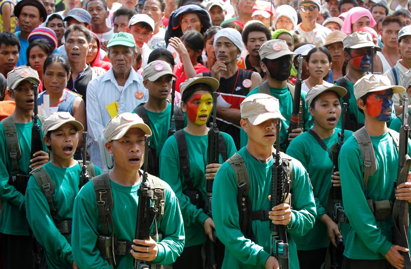 Filipino communist rebels hold their weapons while singing communist ...