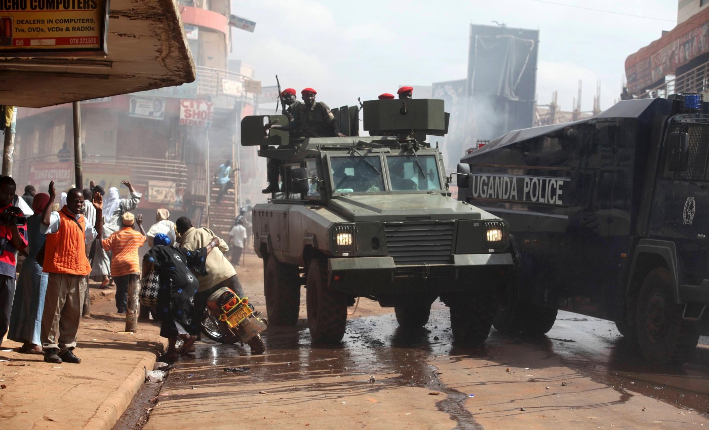Ugandan military police officers patrol along a street during ...