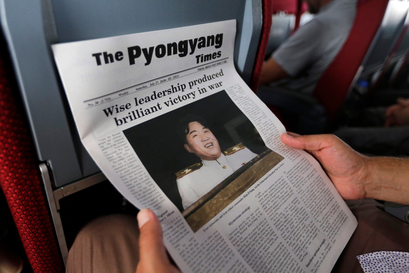 A foreign passenger reads The Pyongyang Times newspaper on an Air Koryo ...