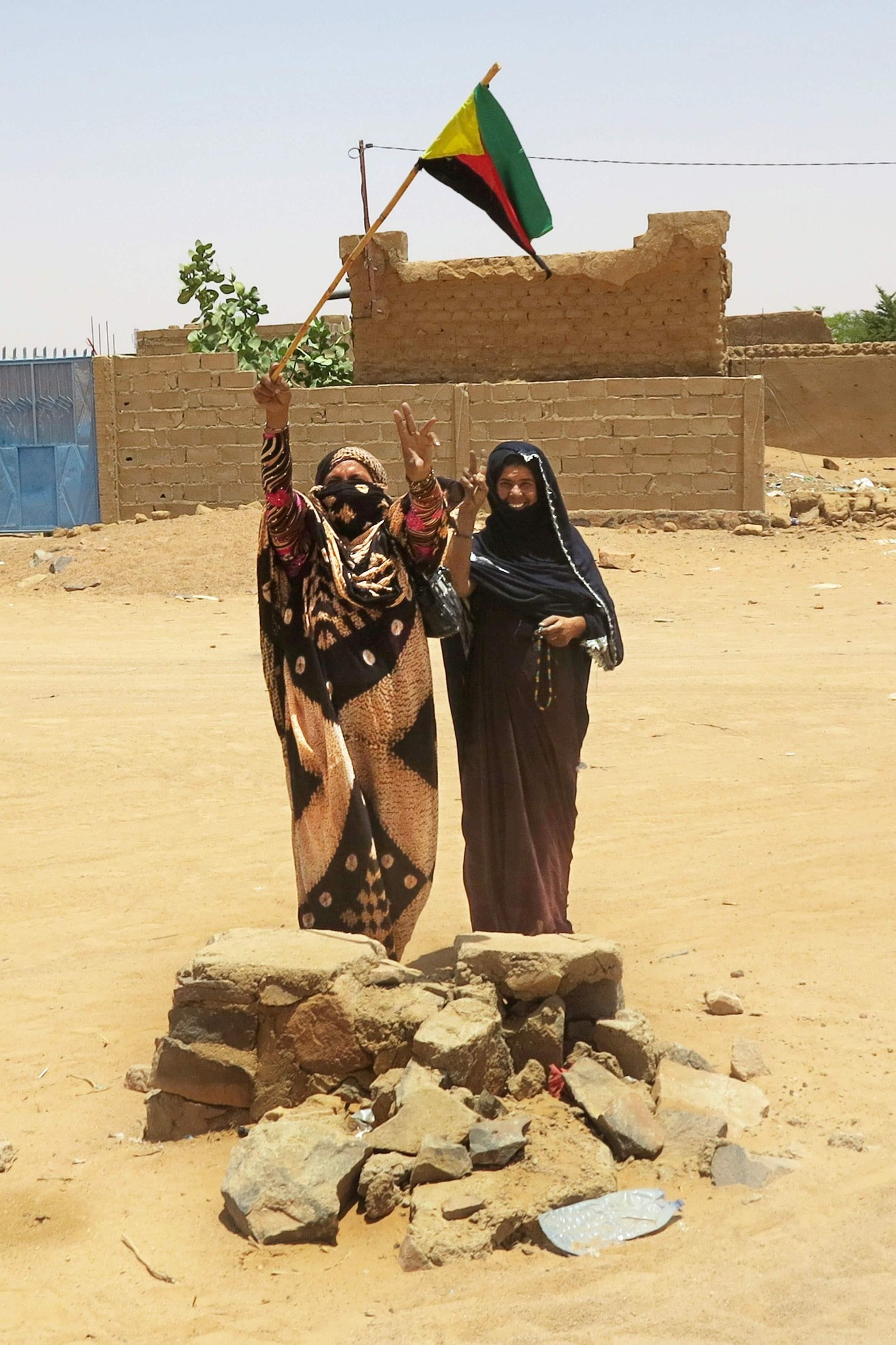 Women wave the flag of the Tuareg separatist group MNLA on a street in ...