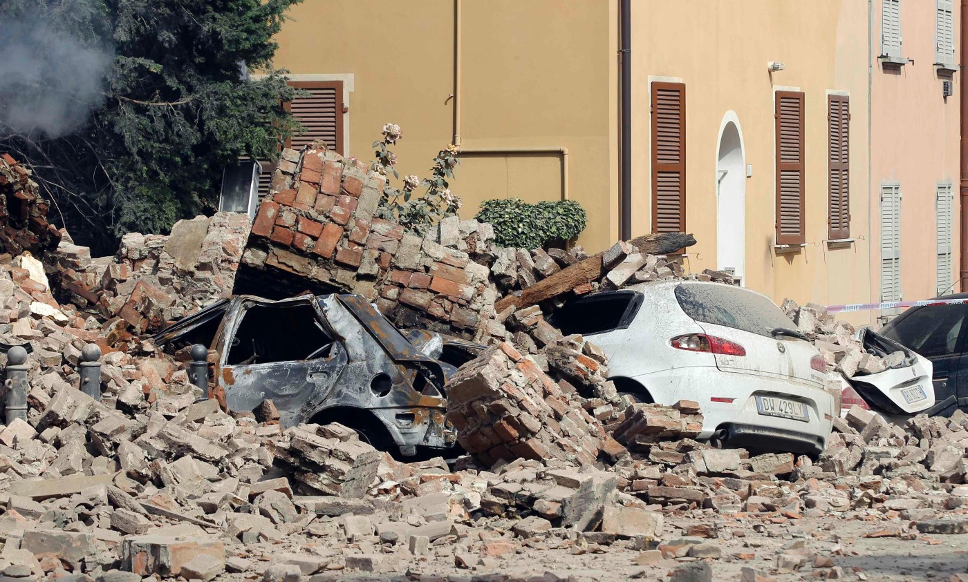 Destroyed cars are seen in the rubble after an earthquake in Finale Emilia